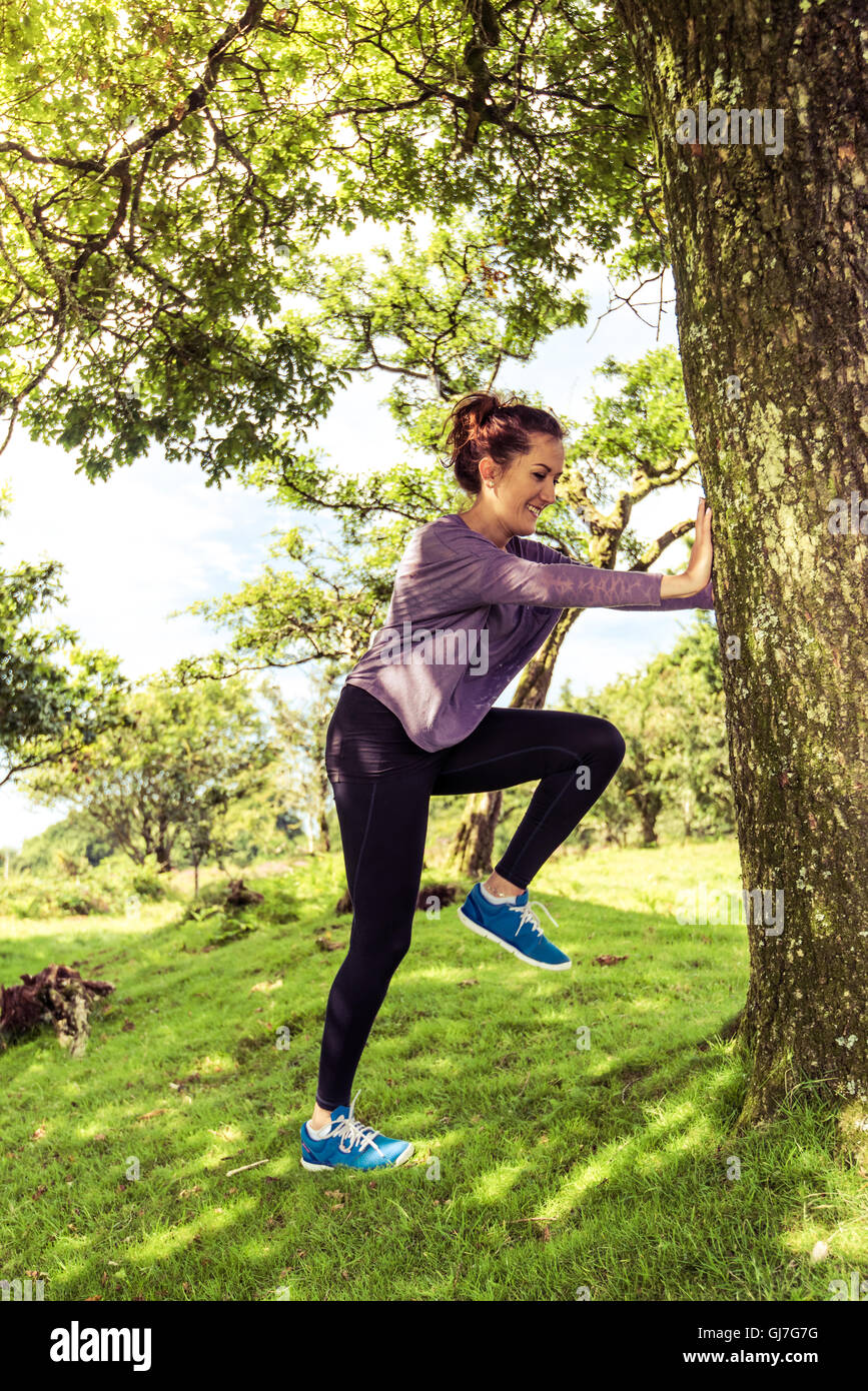 young woman excercise against tree in park Stock Photo - Alamy