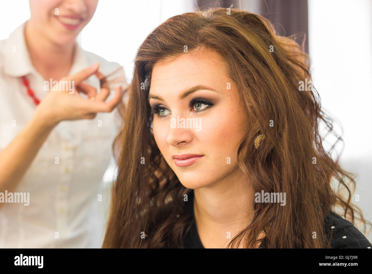 Closeup hairdresser coiffeur makes hairstyle Stock Photo - Alamy