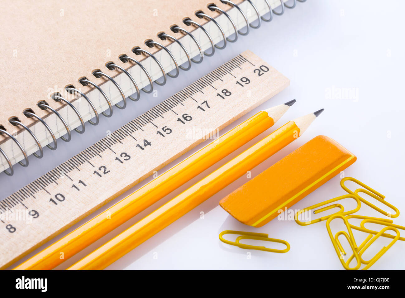 notebook, eraser, ruler, pencil and paperclips on white background ...