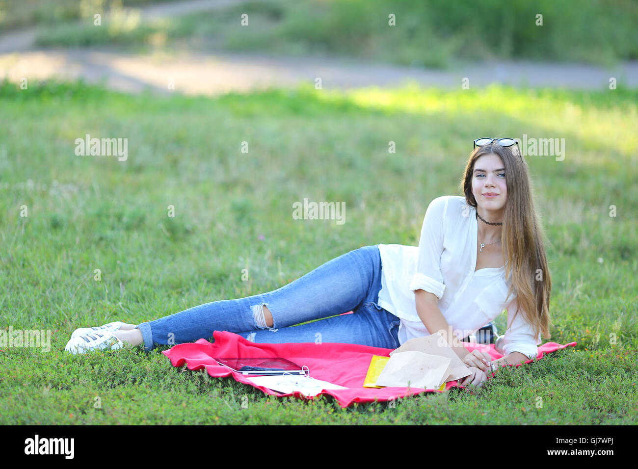 girl lying on the nature and eateth fast food. student working in the ...