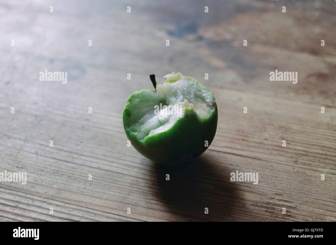 Apple, bitten into, bite, wooden table Stock Photo - Alamy