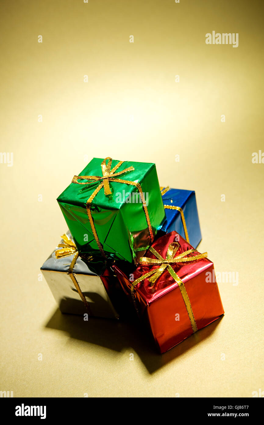 Series of miniature, colorful gift boxes, some on colored backgrounds ...
