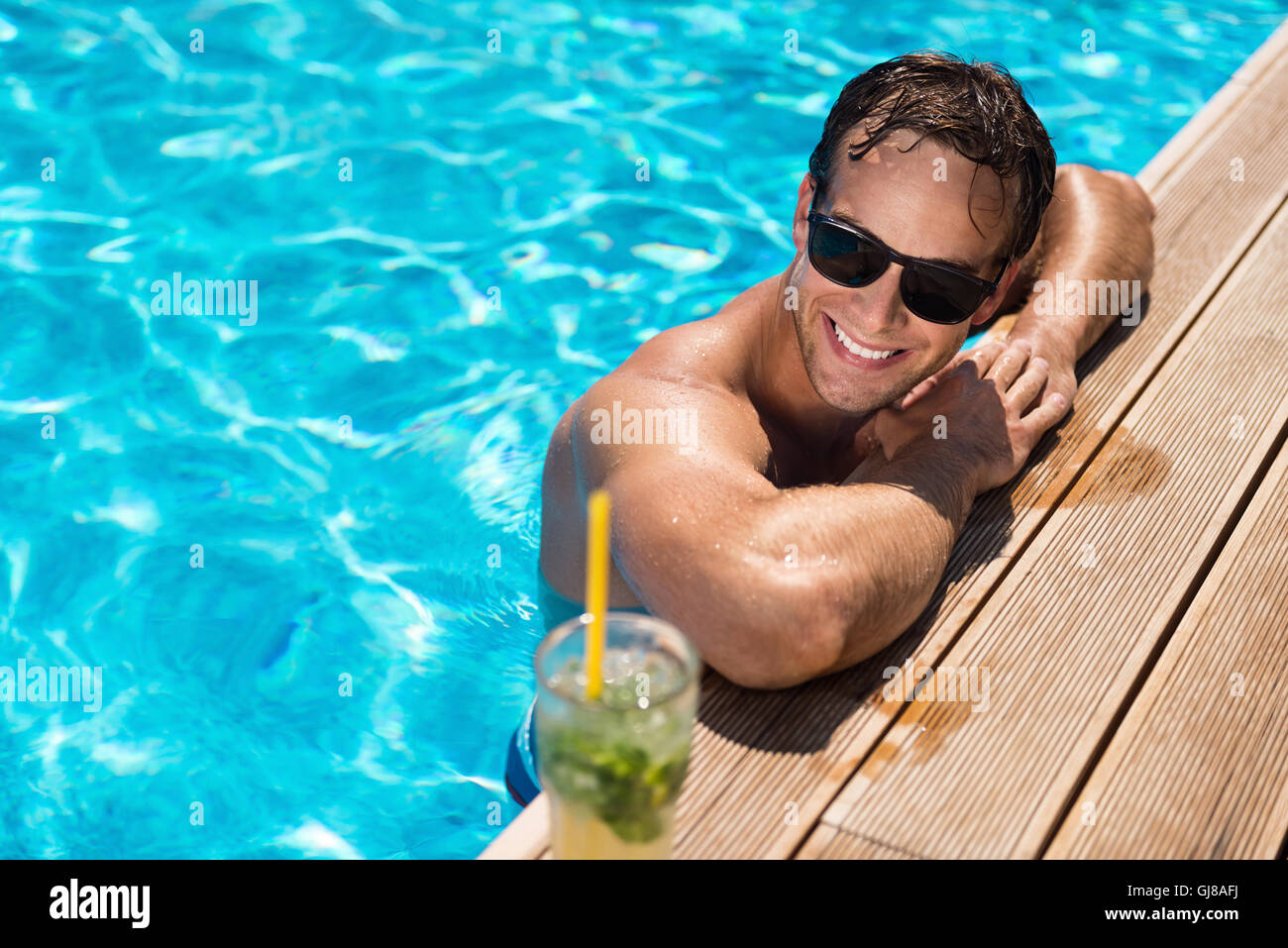Positive man resting in the swimming pool Stock Photo - Alamy