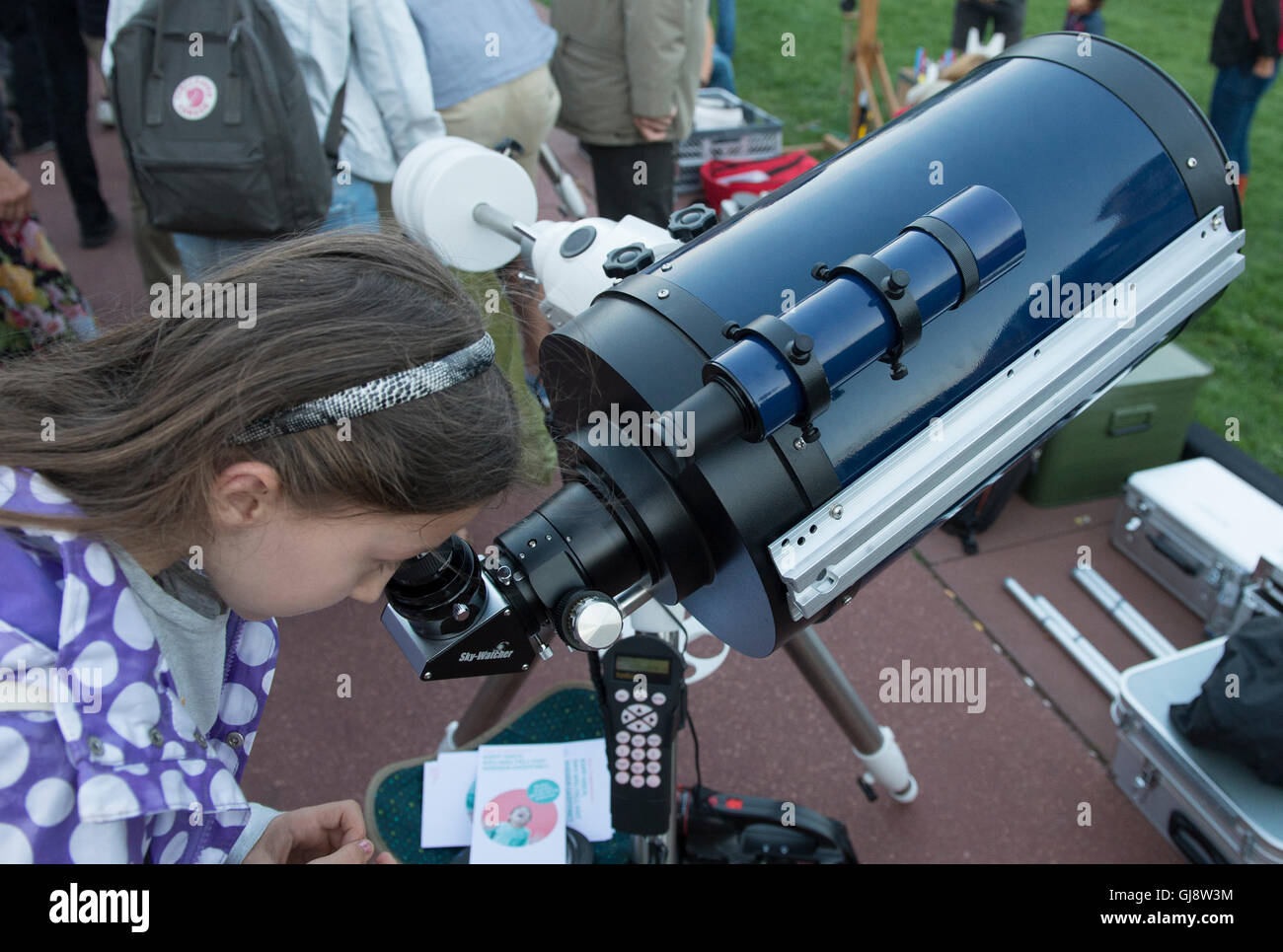 Berlin, Germany. 13th Aug, 2016. A young girl looks through a telescope ...