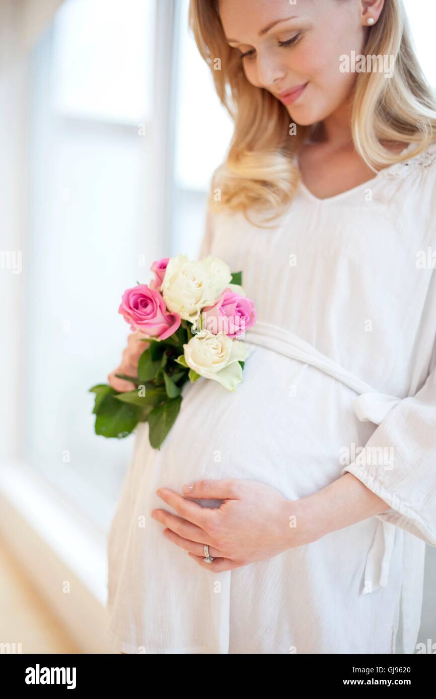 MODEL RELEASED. Pregnant woman holding posy of flowers Stock Photo - Alamy