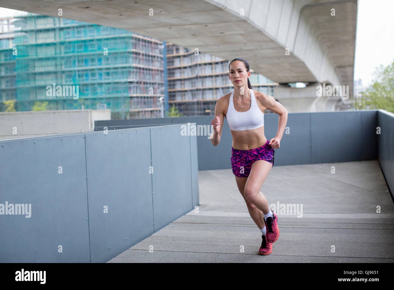 MODEL RELEASED. Young woman running in urban scene Stock Photo - Alamy