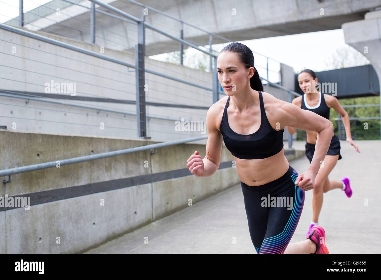 MODEL RELEASED. Two young women running in urban scene Stock Photo - Alamy
