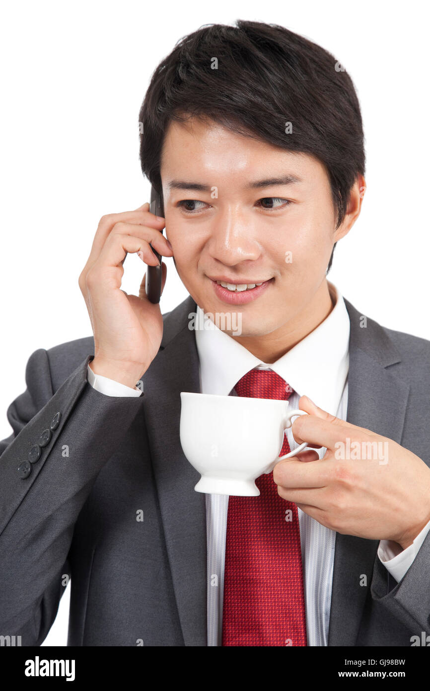 A young man studio shot business attire phone, drinking coffee Stock ...