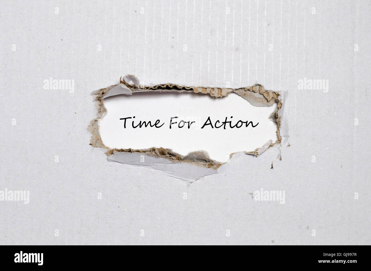 The word time for action appearing behind torn paper Stock Photo - Alamy