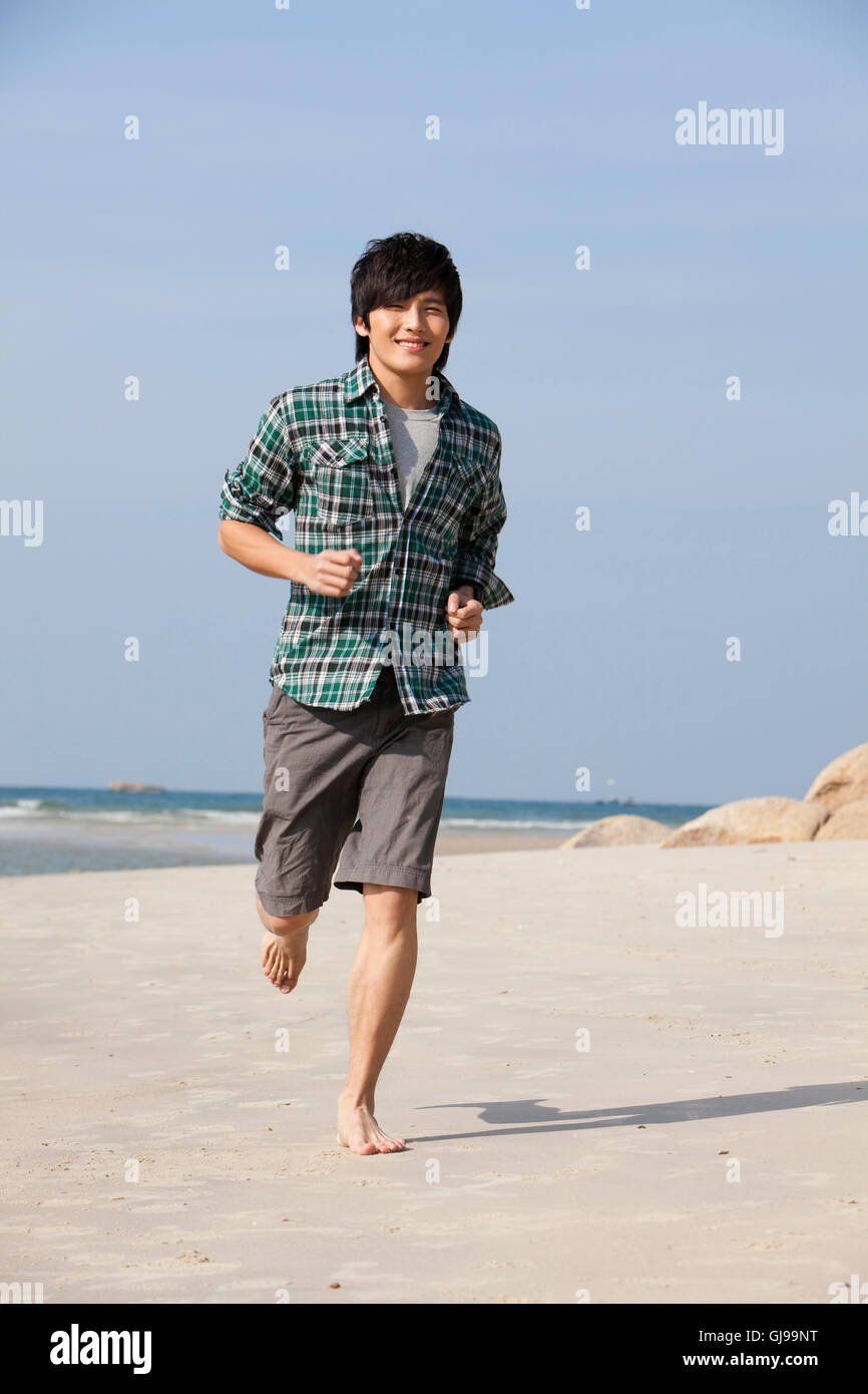 Seaside Casual Young man running Stock Photo - Alamy