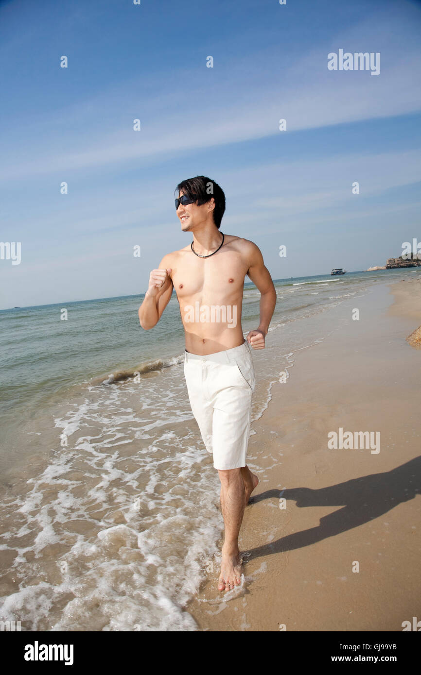 Seaside Casual Young man running Stock Photo - Alamy