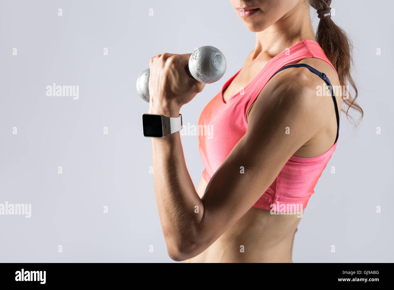 Close-up of torso of beautiful young fitness person wearing smartwatch ...