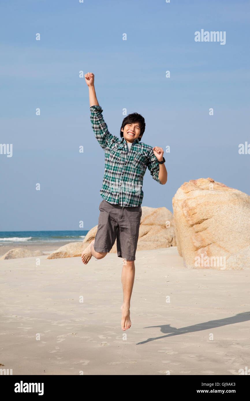 Young man jumping at the beach Stock Photo - Alamy