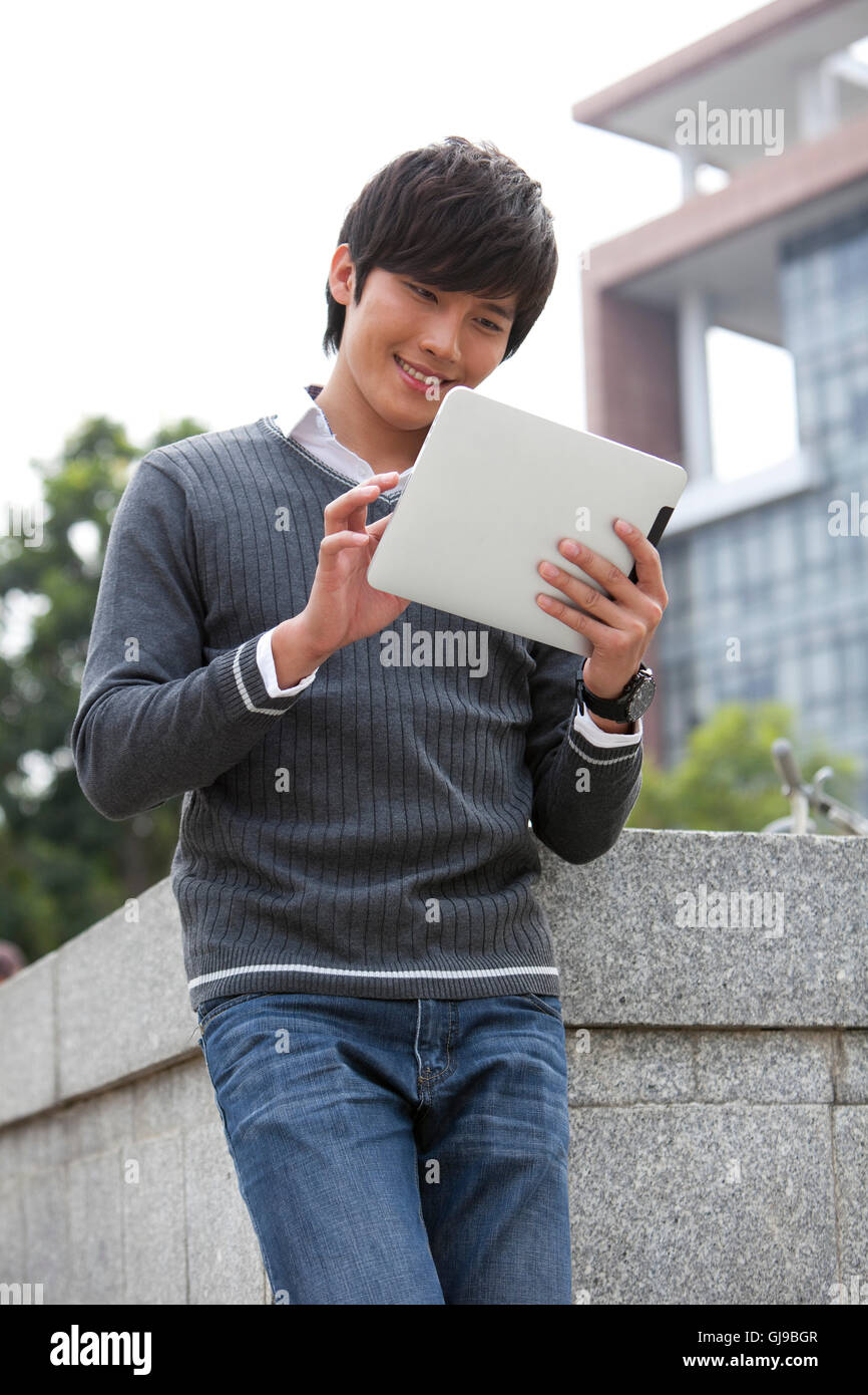Young university student using a tablet on campus Stock Photo - Alamy