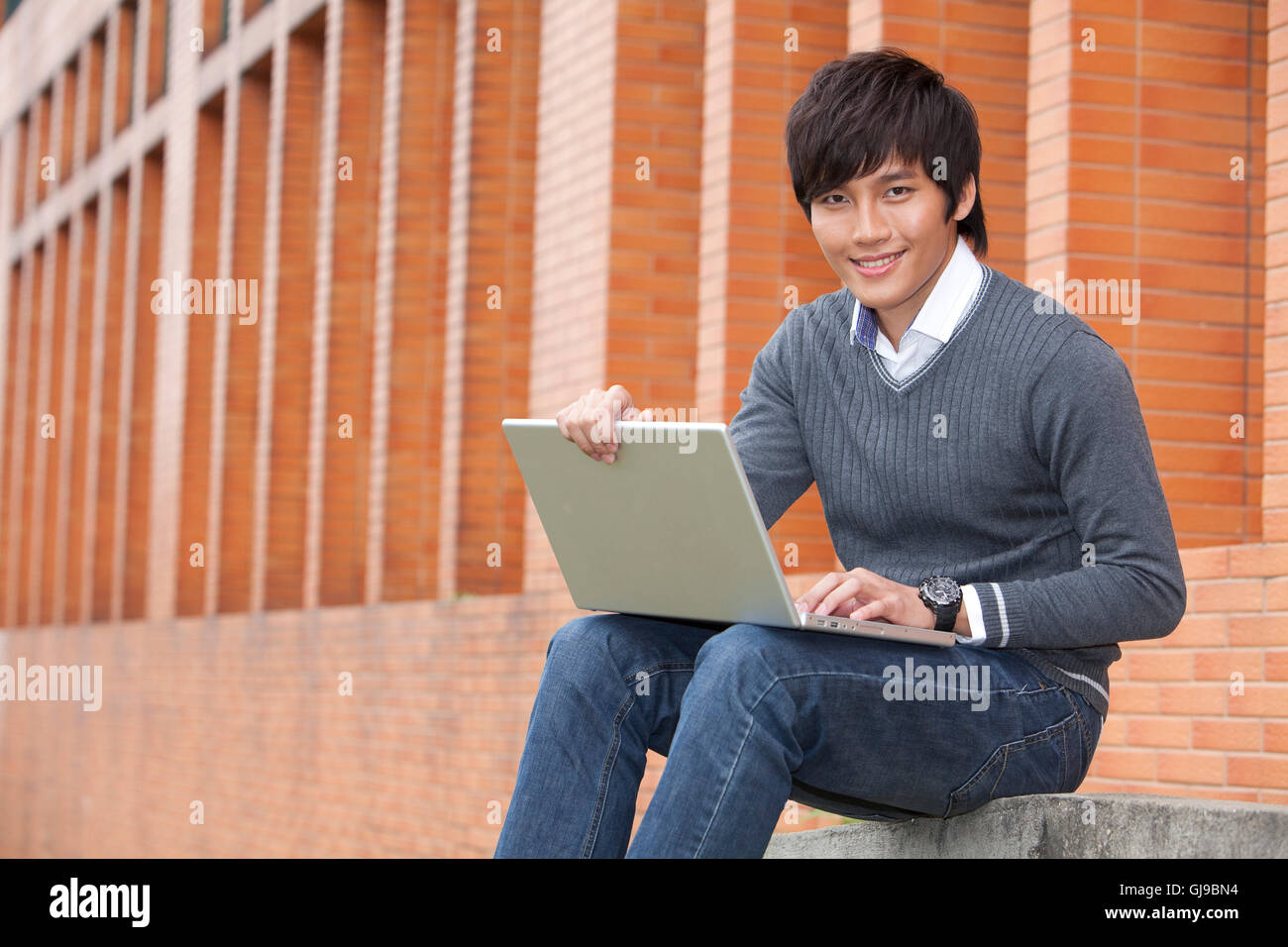 Young college students using laptop on campus Stock Photo - Alamy