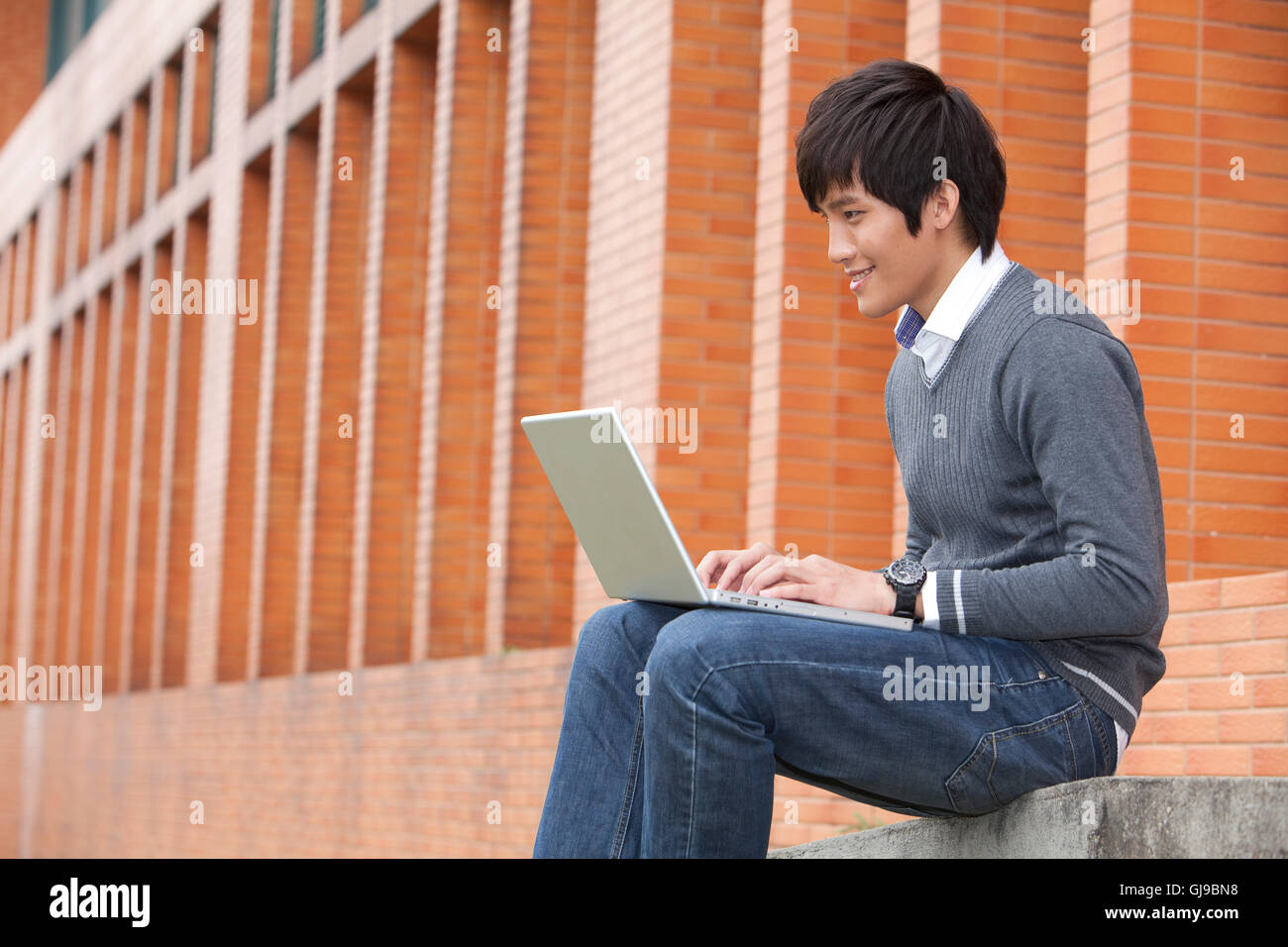 Young college students using laptop on campus Stock Photo - Alamy