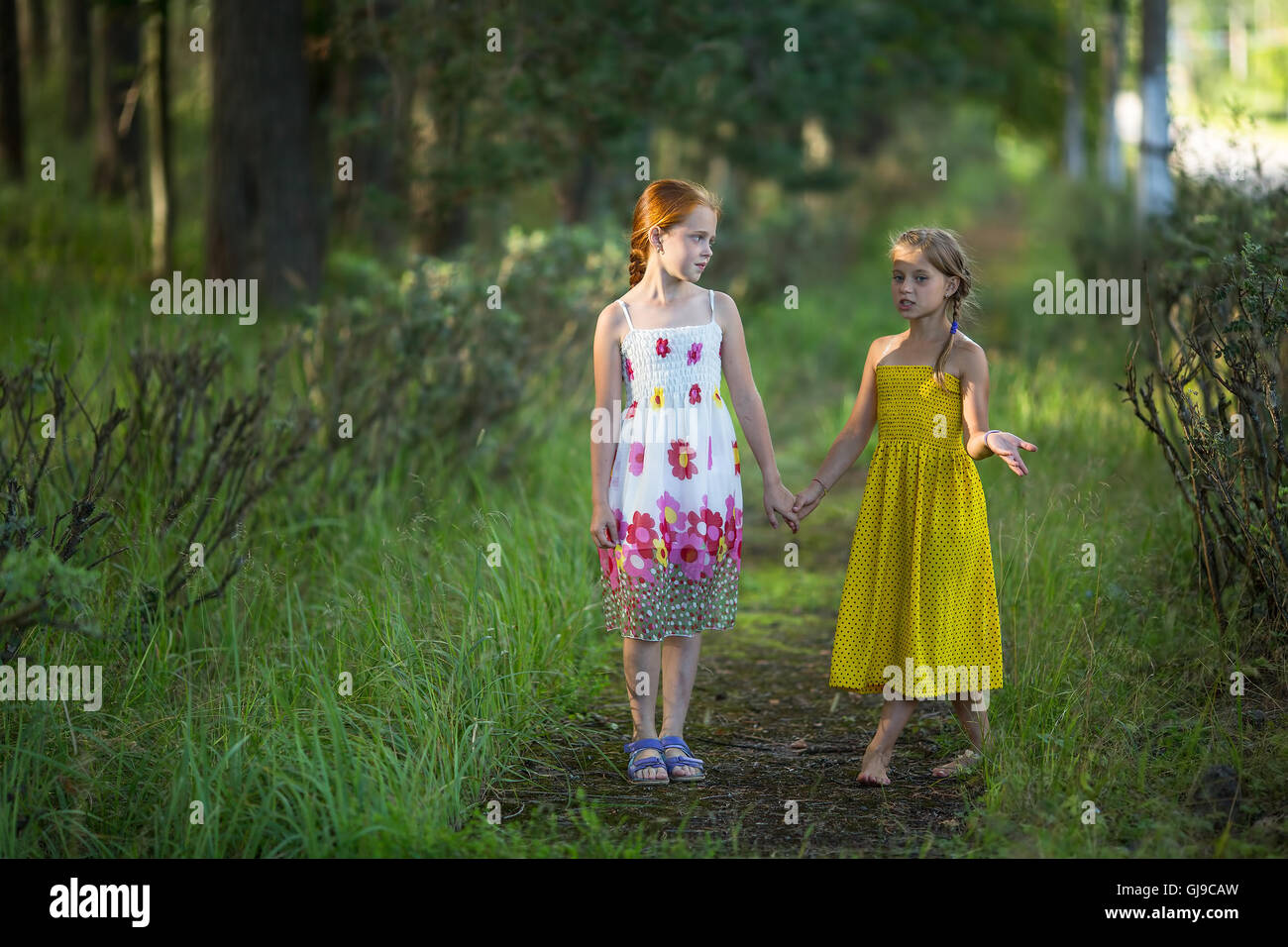 Two kids girls talking in the Park holding hands Stock Photo - Alamy