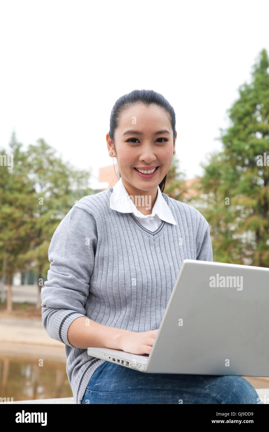 Young college students using laptop on campus Stock Photo - Alamy