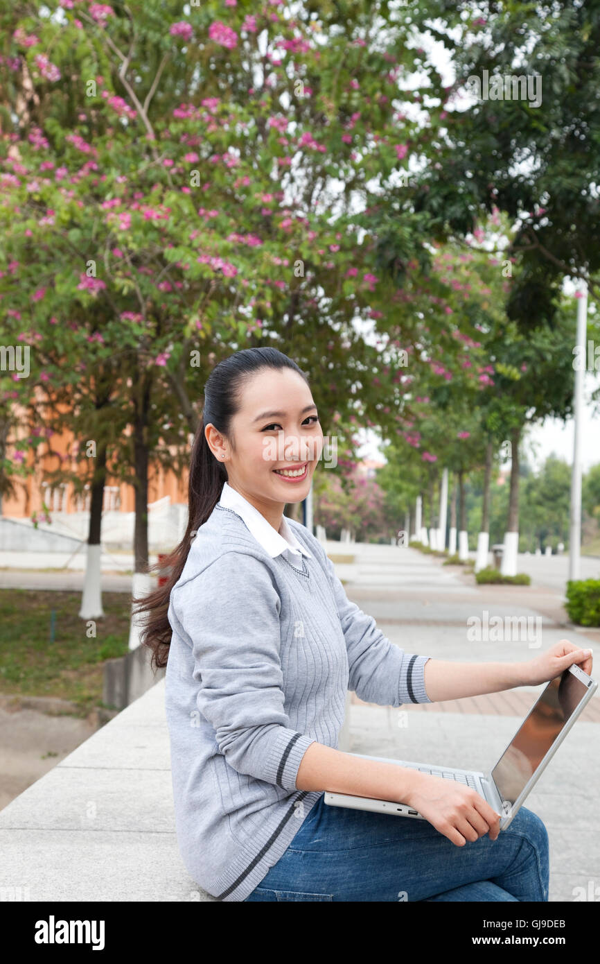 Young college students using laptop on campus Stock Photo - Alamy