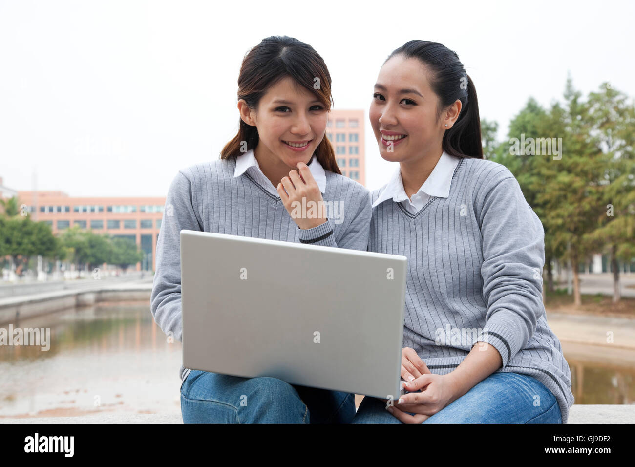 Young college students using laptop on campus Stock Photo - Alamy