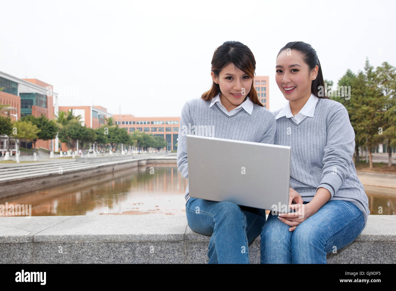 Young college students using laptop on campus Stock Photo - Alamy