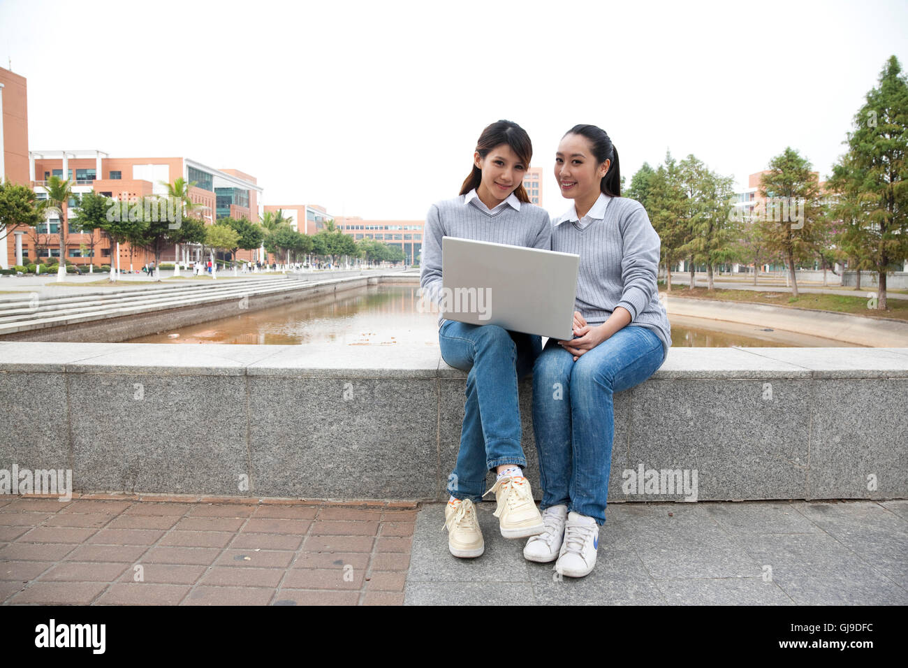 Young college students using laptop on campus Stock Photo - Alamy