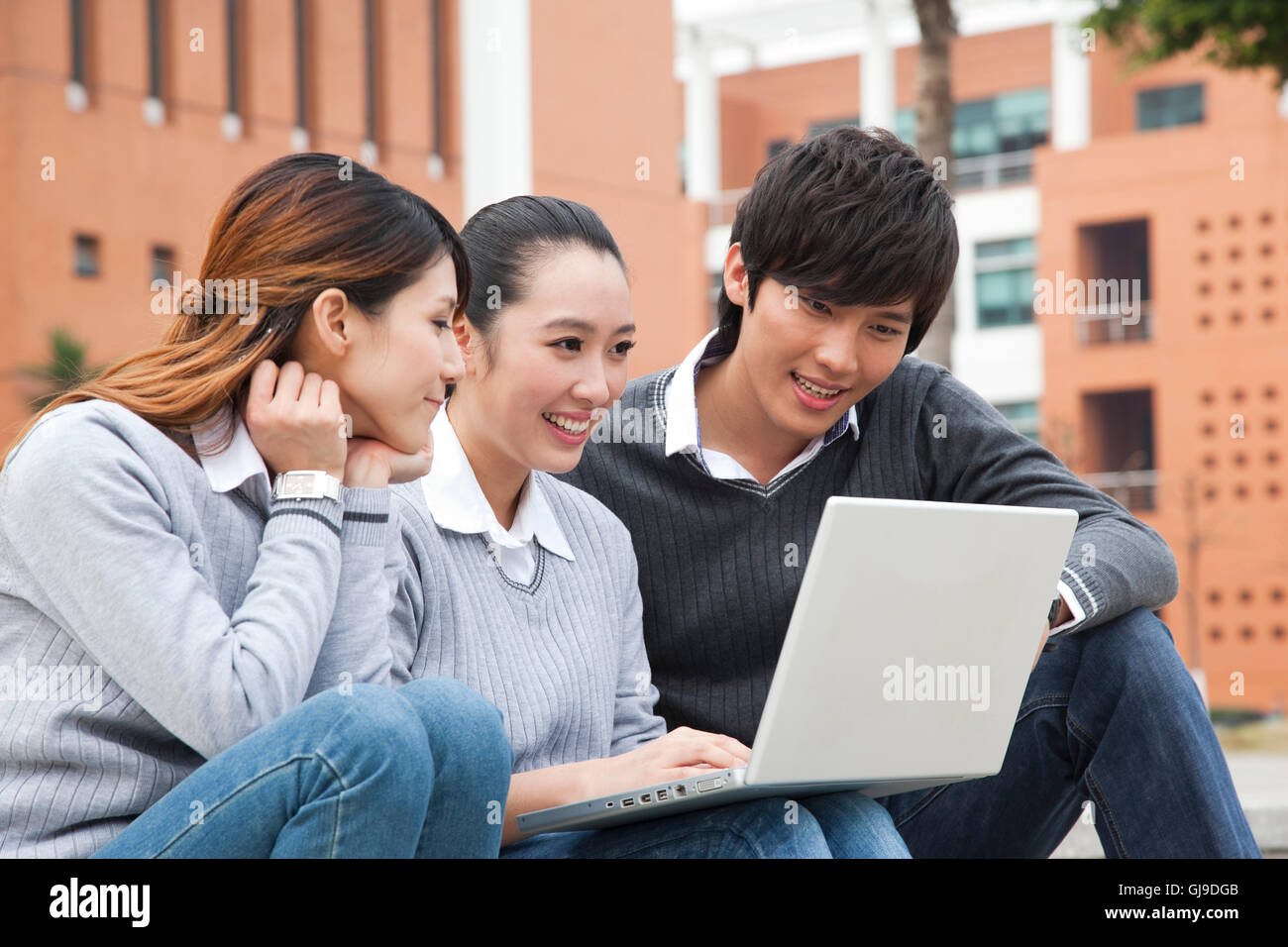 Young college students using laptop on campus Stock Photo - Alamy