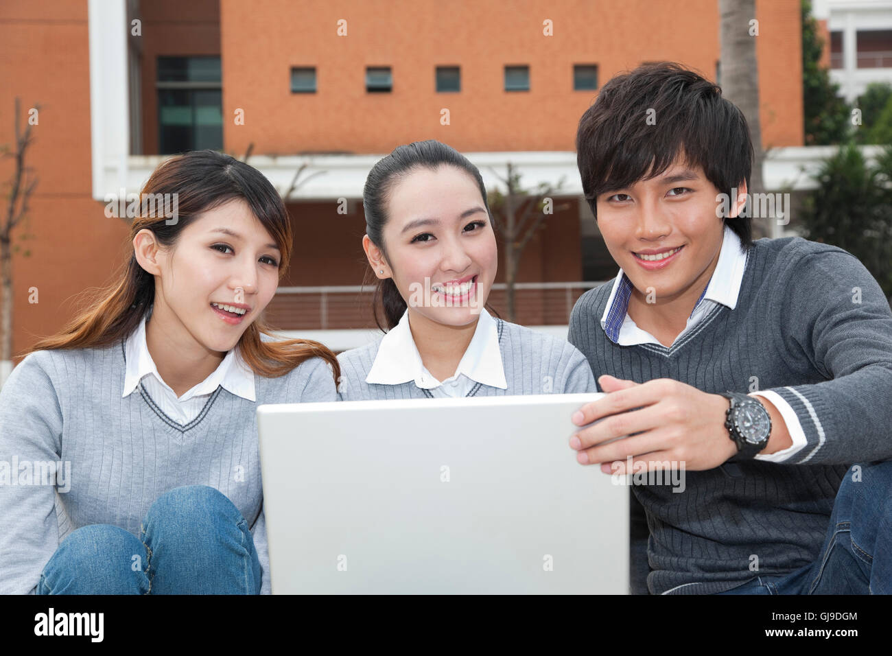Young college students using laptop on campus Stock Photo - Alamy