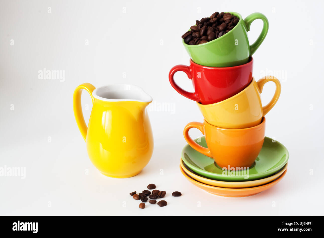 Colorful cups and yellow jug Stock Photo - Alamy