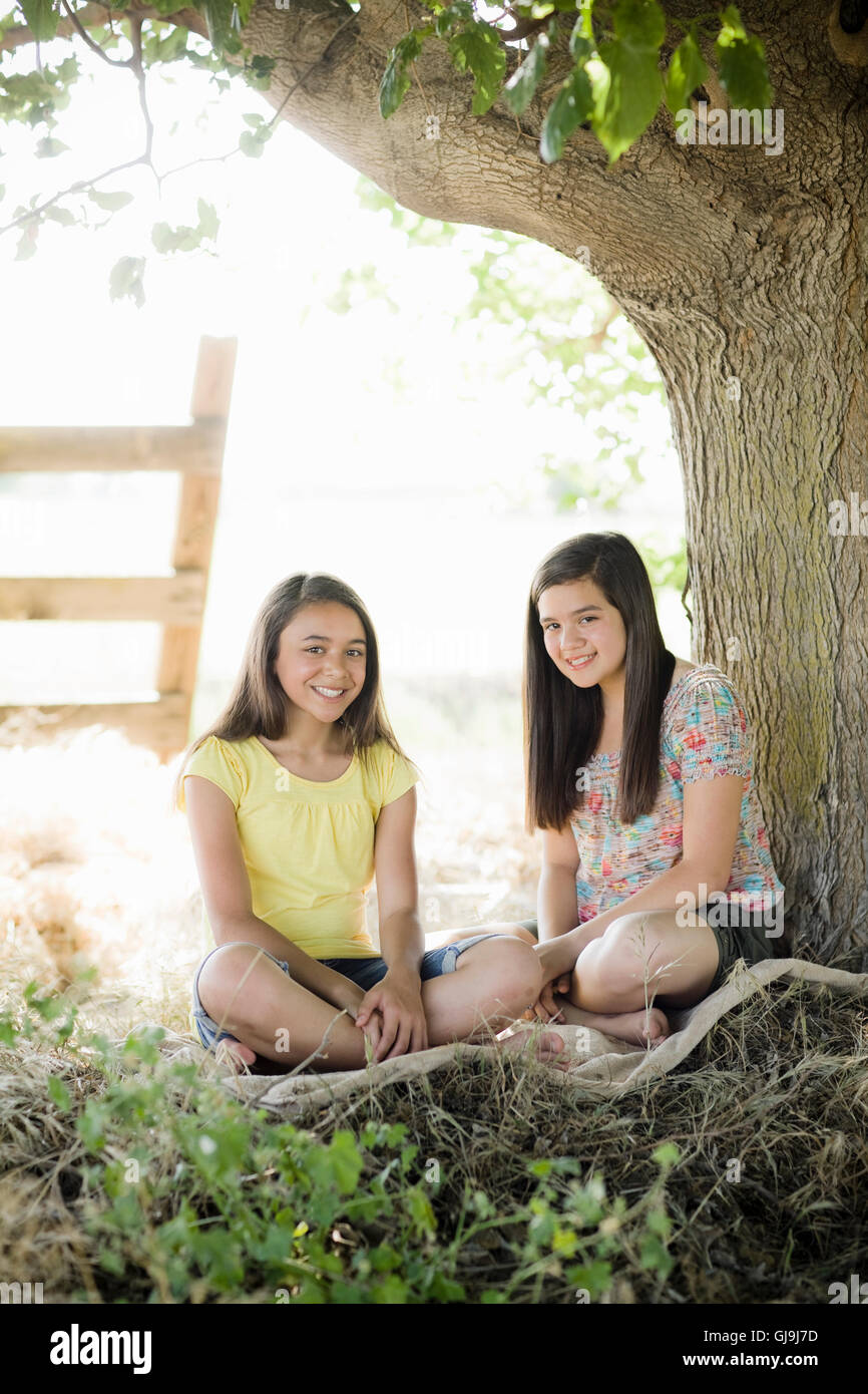Two Girls Under a Tree Stock Photo - Alamy