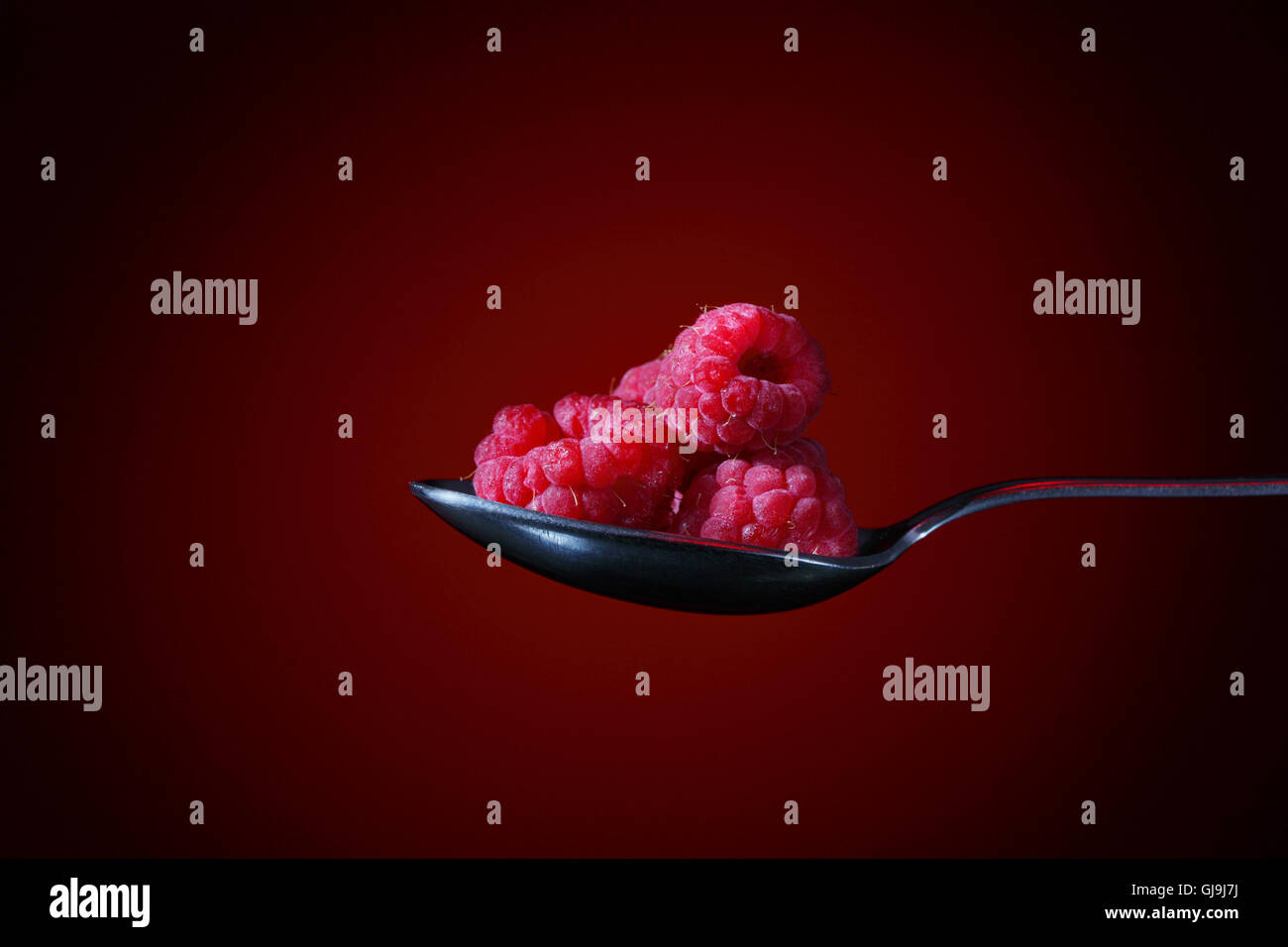 Color photo of pile of red rasberry on metal spoon Stock Photo - Alamy