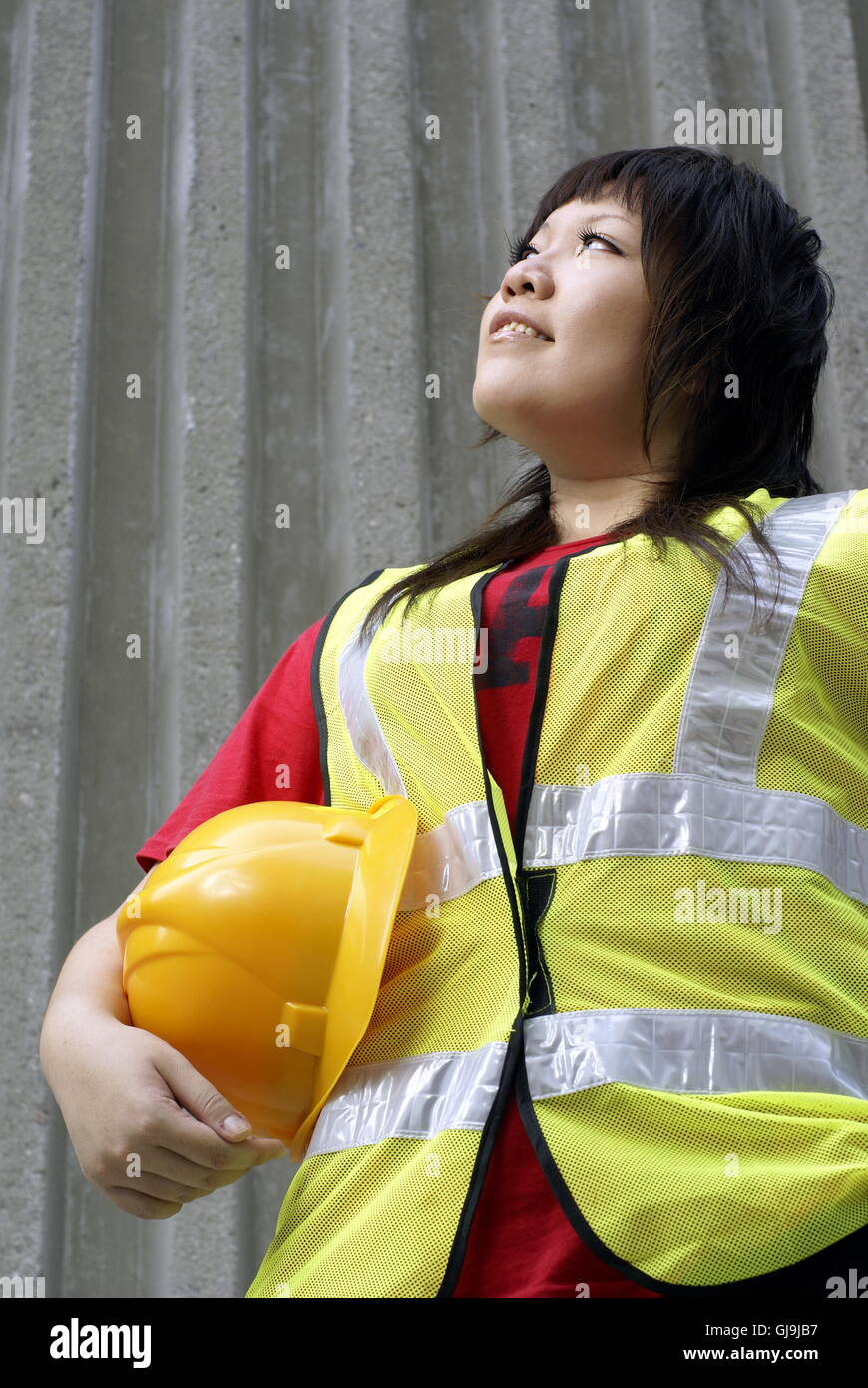 Asian female construction contractor lady looking up with concrete wall ...