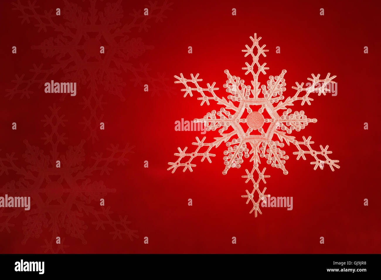 white snow flake on a red background with copy space on left sid Stock ...