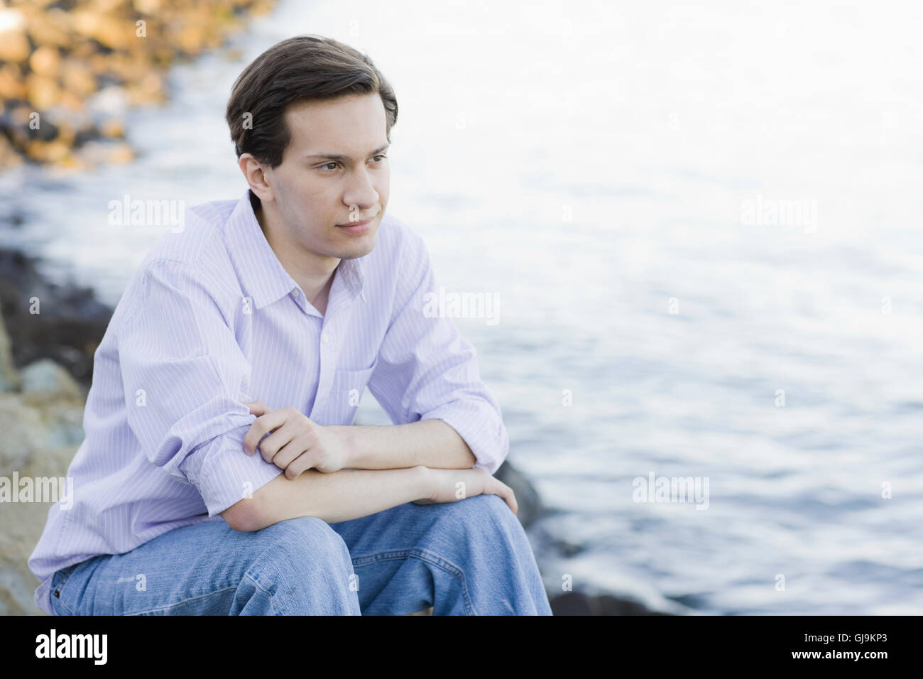 Teenage Boy Sitting on Rocks Stock Photo - Alamy
