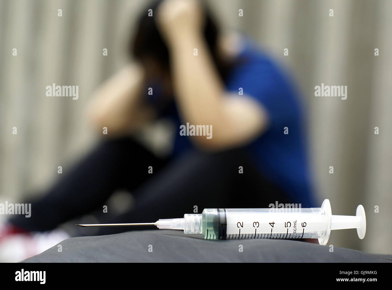 Syringe and female addict in anguish Stock Photo - Alamy