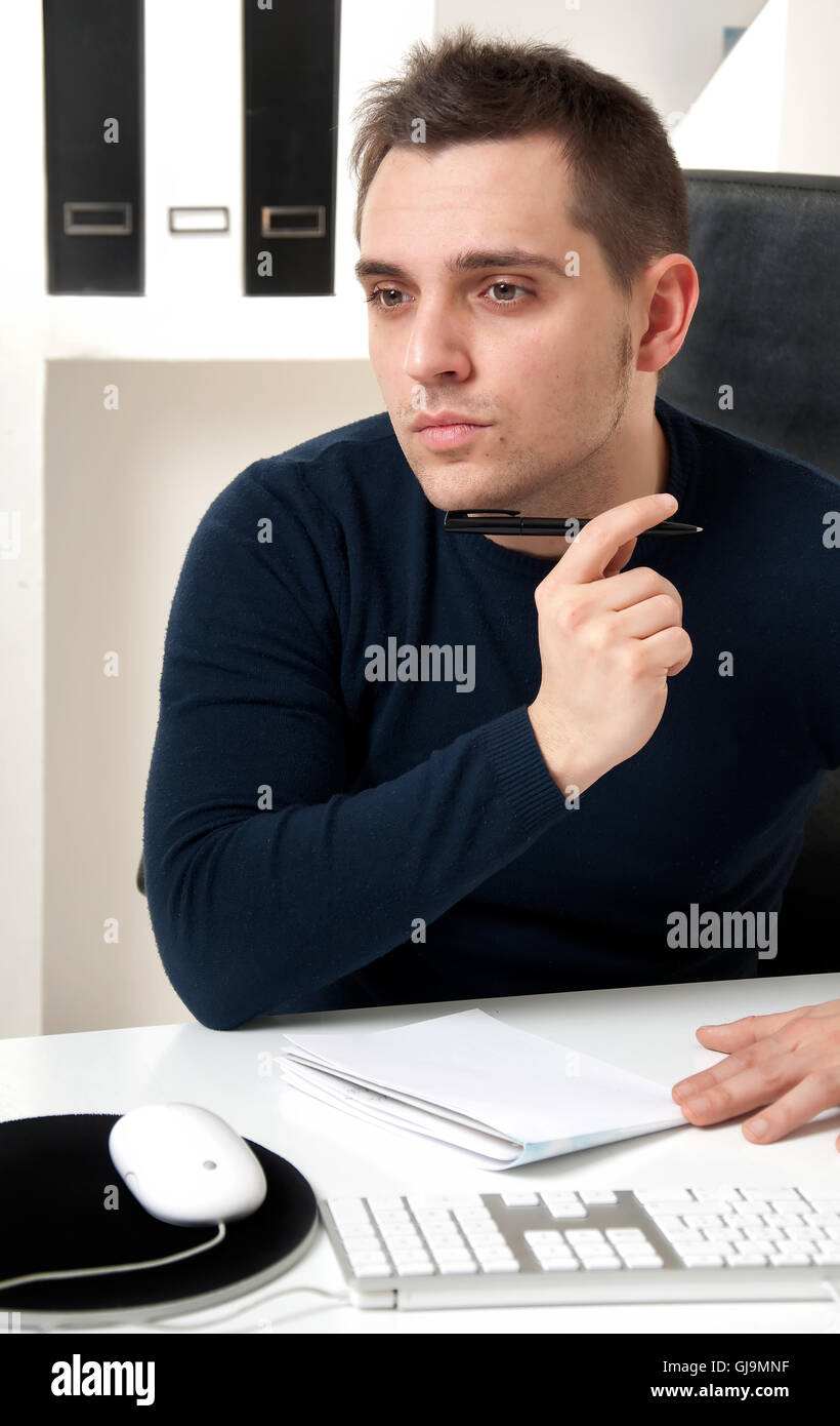 Young man thinking in front of his computer Stock Photo - Alamy