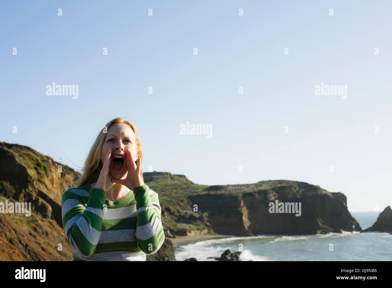 Woman Yelling On Cliff Stock Photo - Alamy