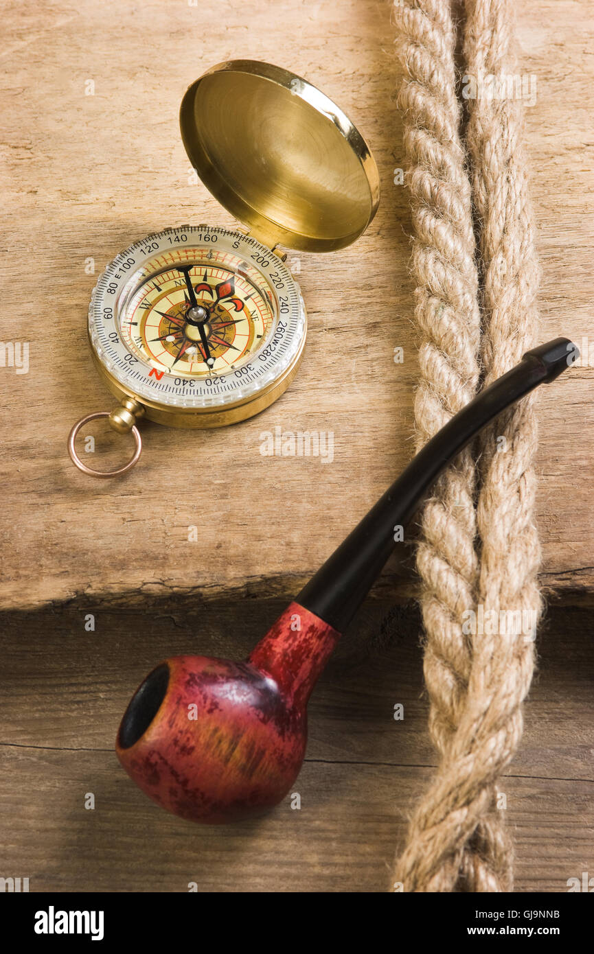 Compass and a pipe with a rope Stock Photo - Alamy