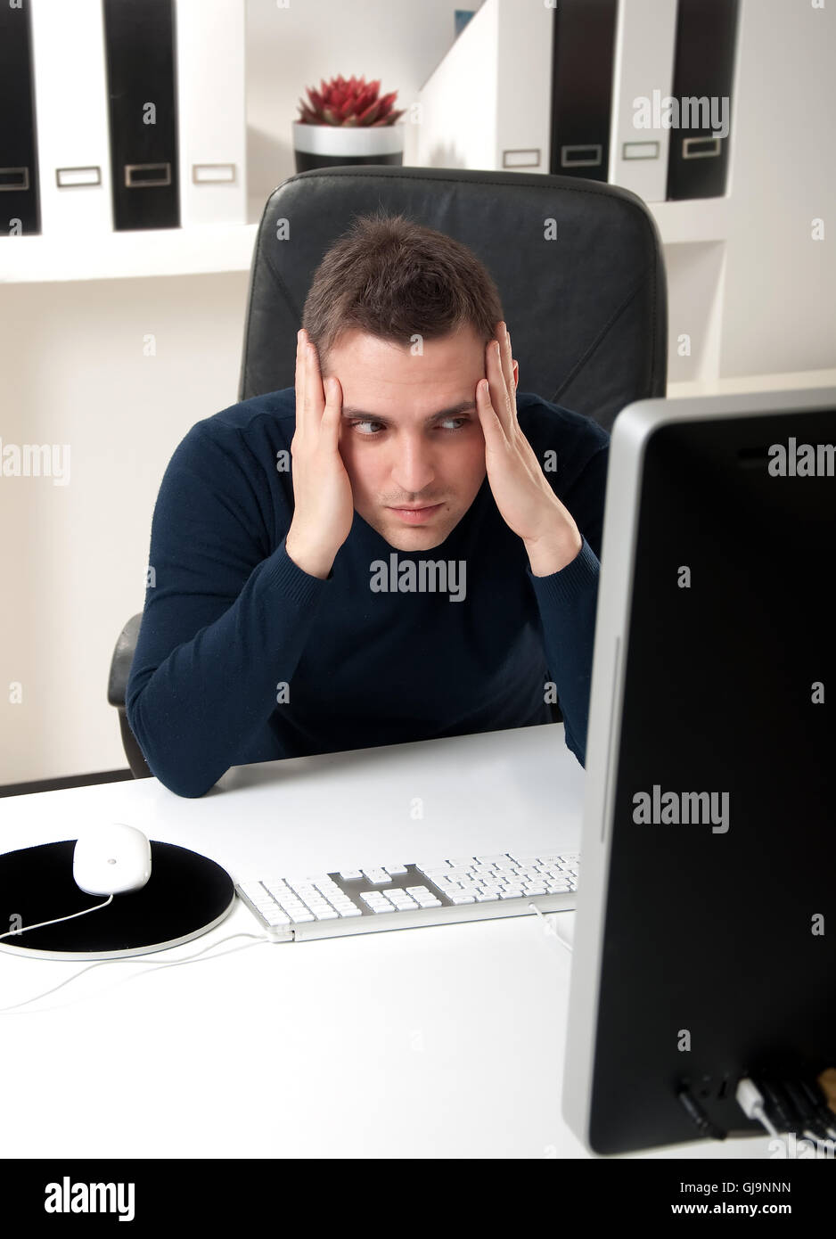 Young man thinking in front of his computer Stock Photo - Alamy