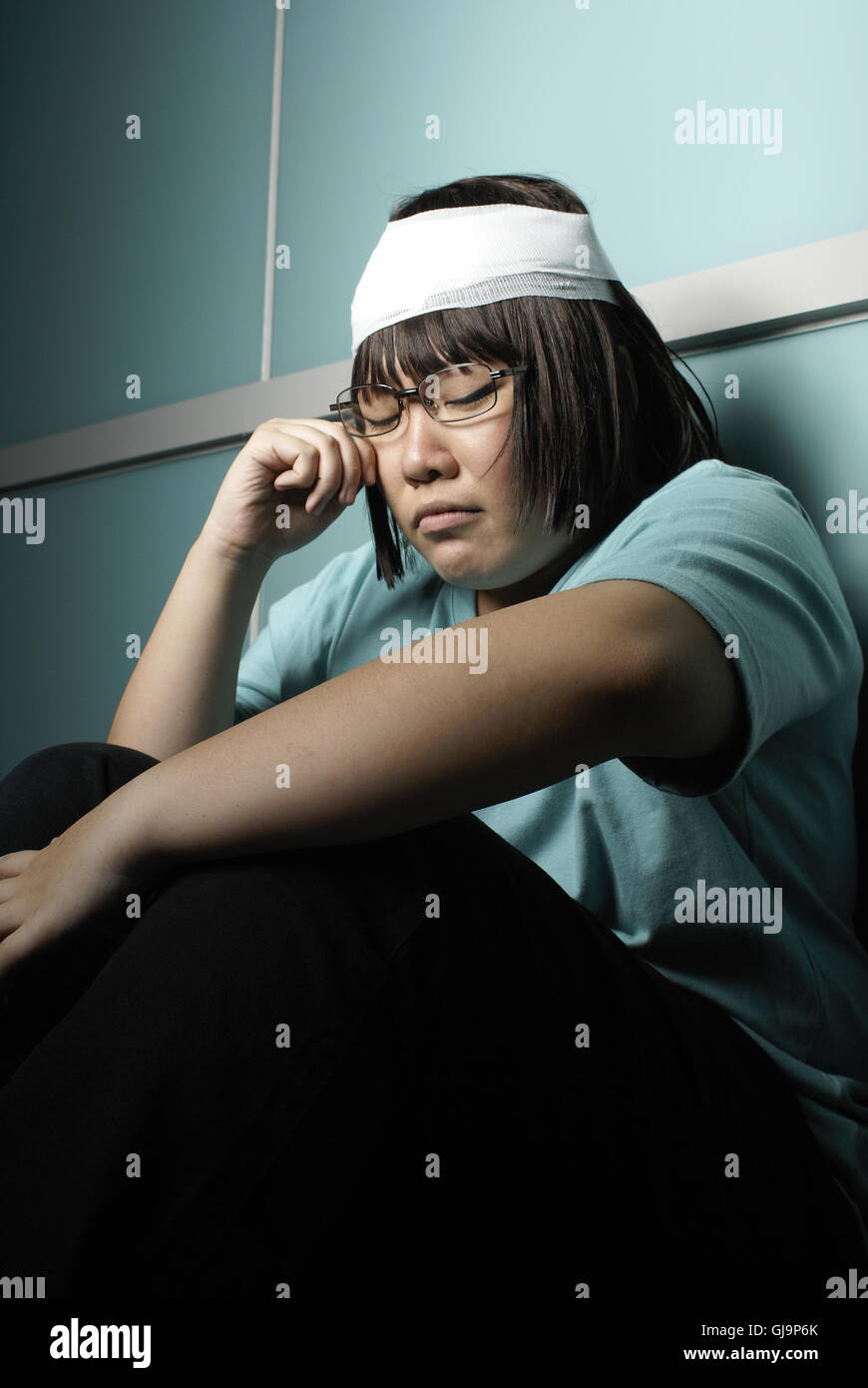 Injured and miserable teen girl unhappy crouched on floor Stock Photo ...
