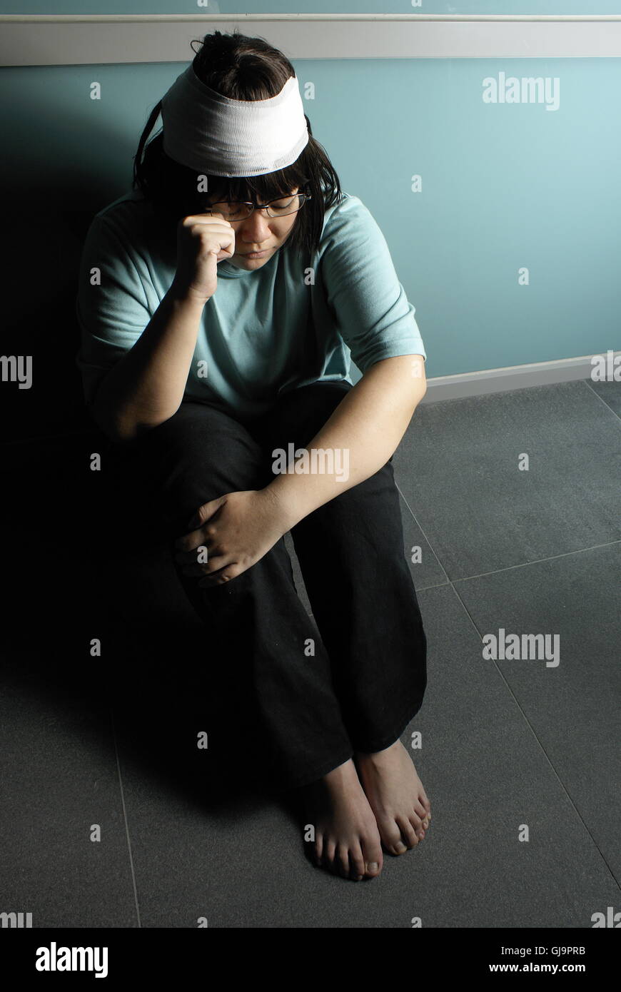 Injured and miserable teen girl unhappy crouched on floor Stock Photo ...