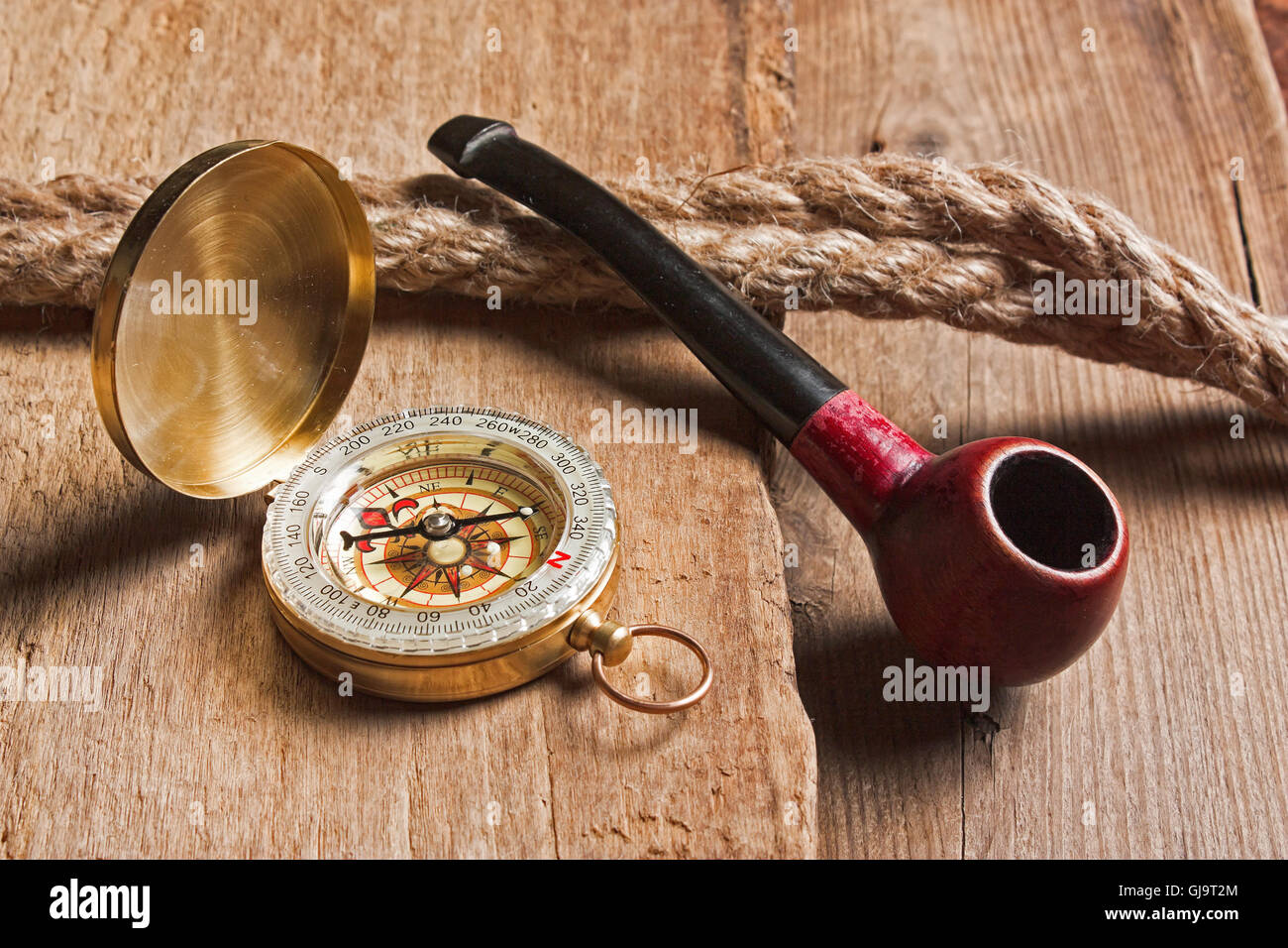 Compass and a pipe with a rope Stock Photo - Alamy