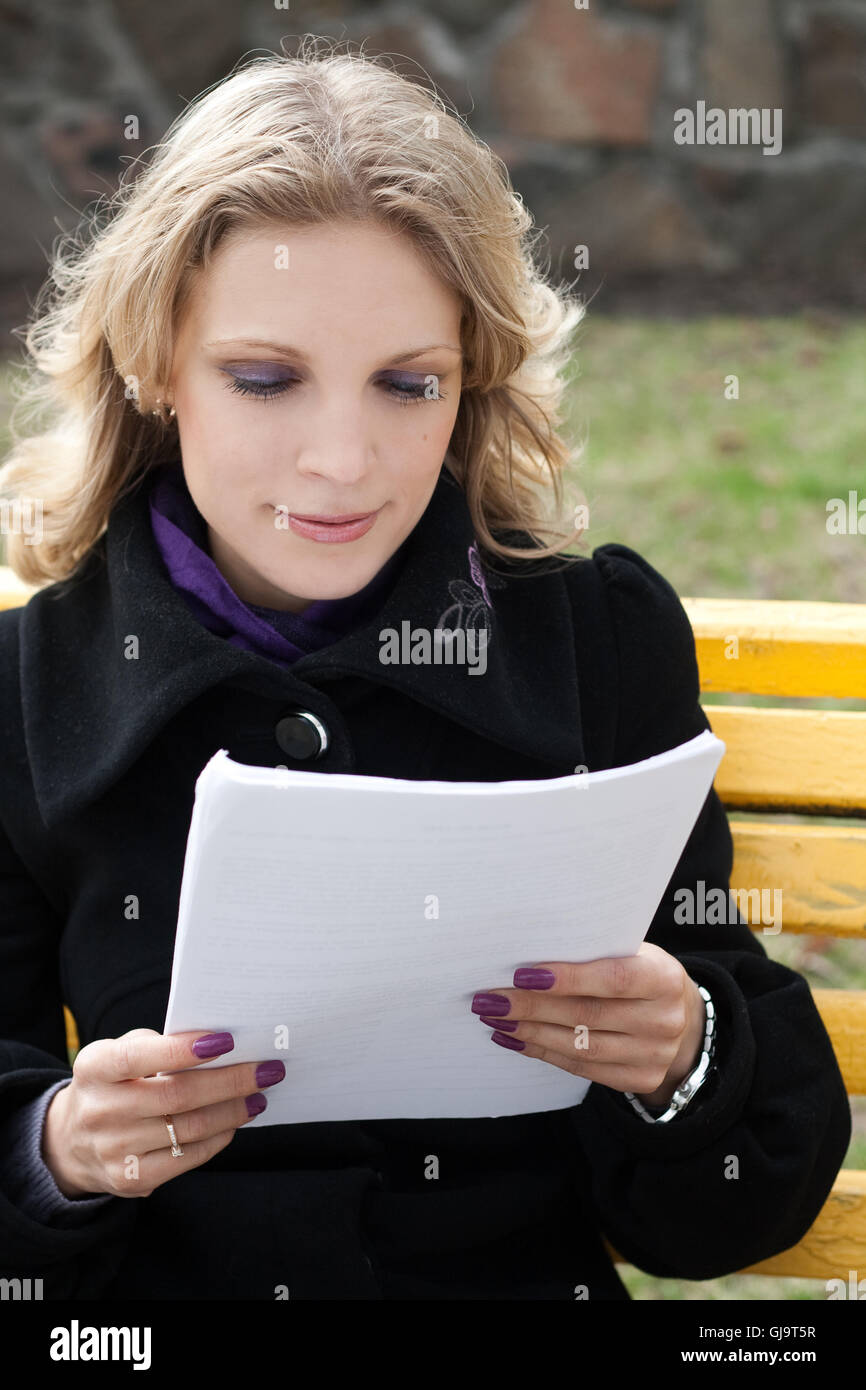 Business young woman looks in the paper Stock Photo - Alamy