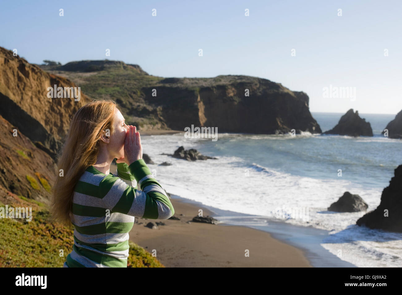 Woman Yelling on Cliff Stock Photo - Alamy