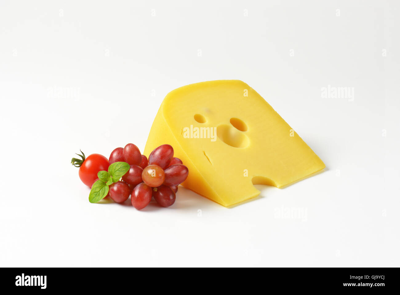 wedge of fresh cheese with red grapes on white background Stock Photo ...