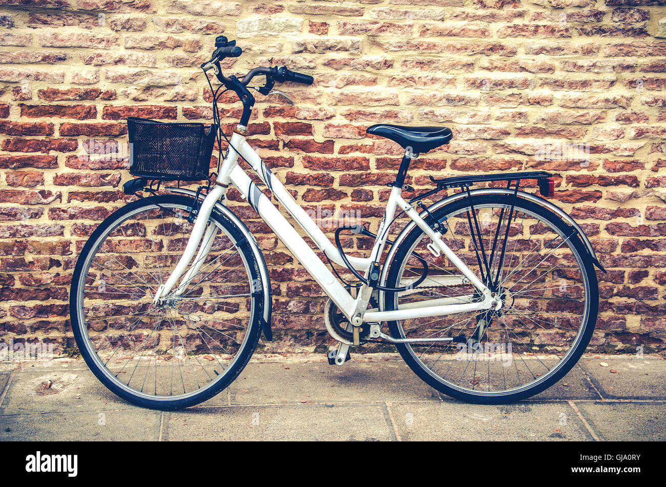 bike lean to a brick wall Stock Photo - Alamy