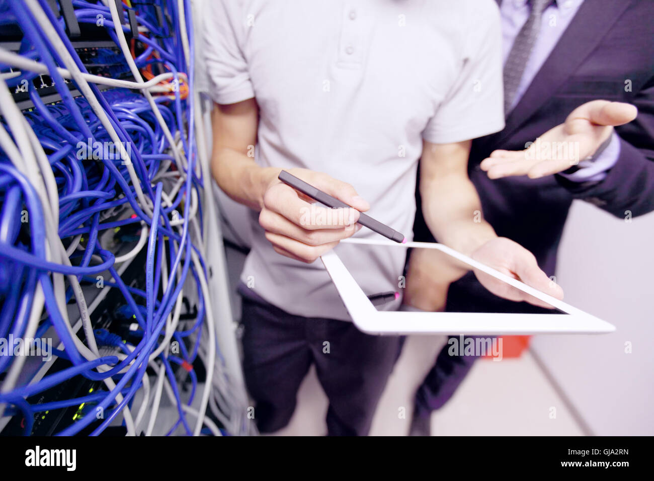 Young engeneer and business man in network server room with digital ...