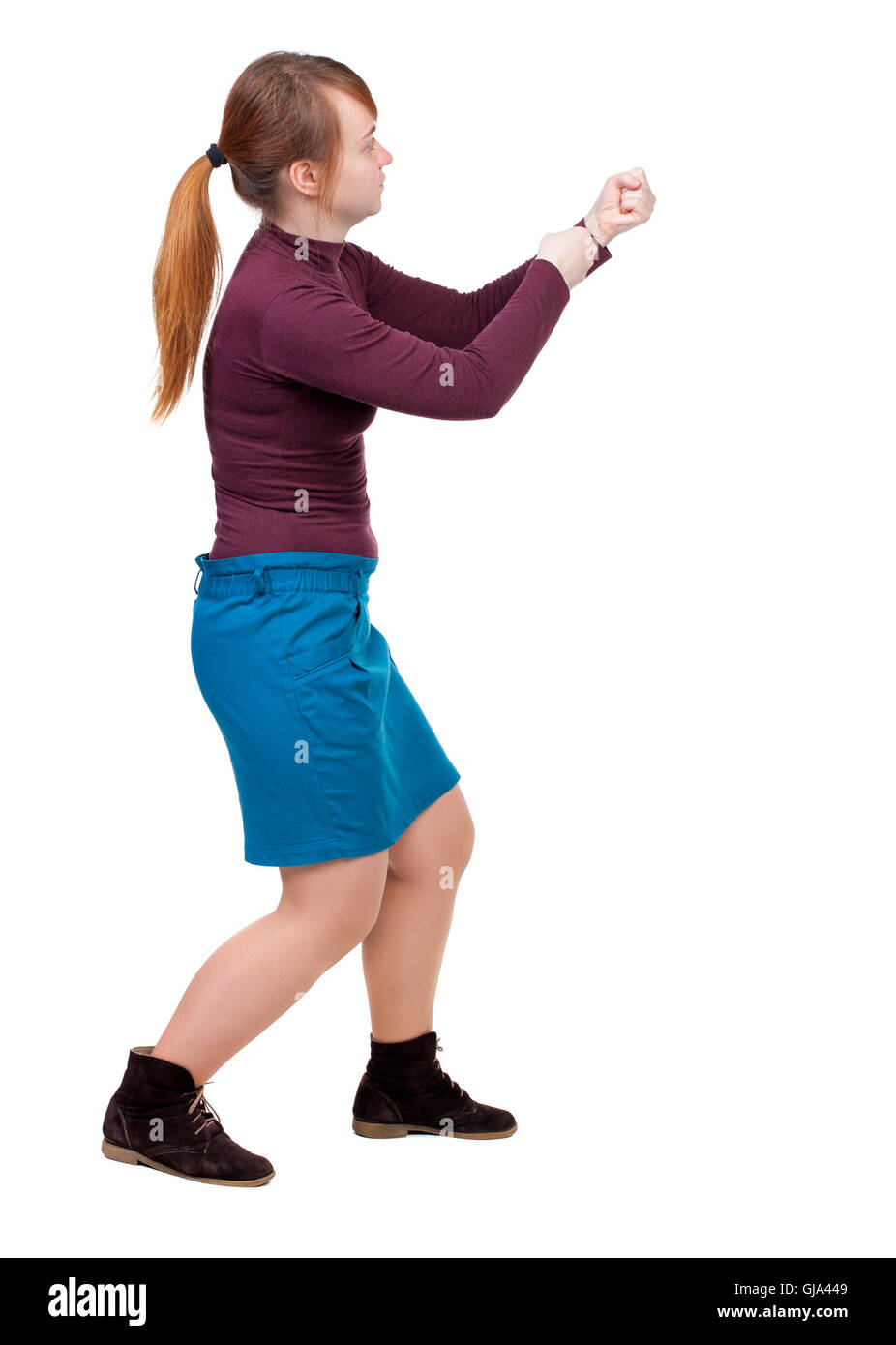 back view of standing girl pulling a rope from the top or cling Stock ...