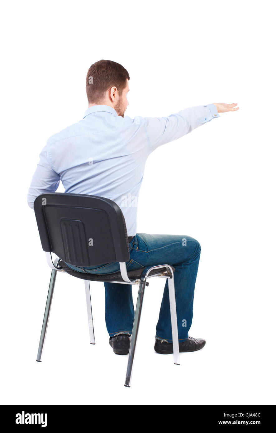 back view of young business man sitting on chair and pointing Stock ...