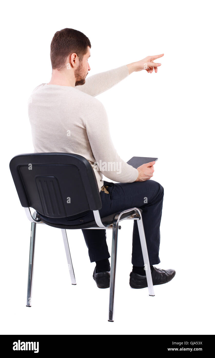 back view of pointing man sitting on chair and looks at screen o Stock ...